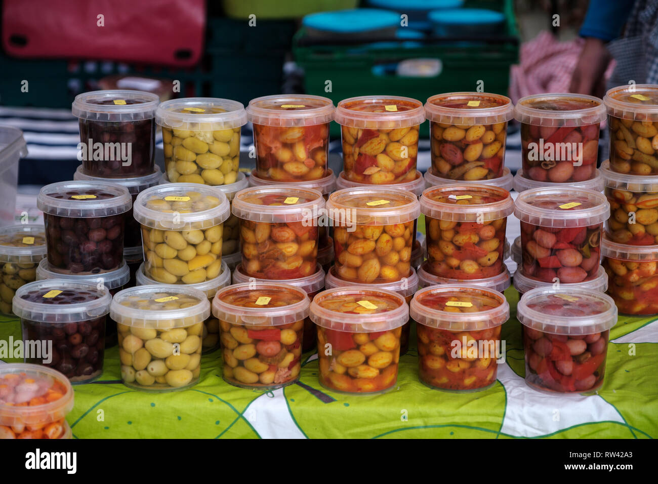 A variety of different types of marinaded olives stacked in plastic ...