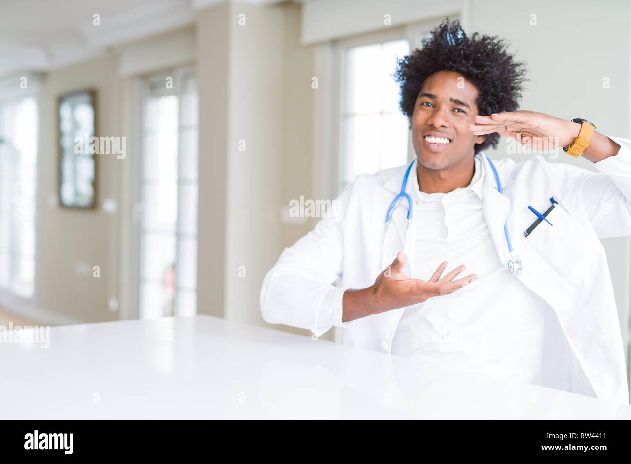 African American doctor man at the clinic gesturing with hands showing ...