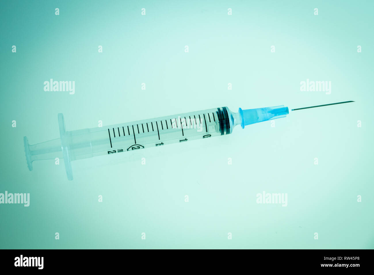 Injection syringe on a clean blue background Stock Photo - Alamy