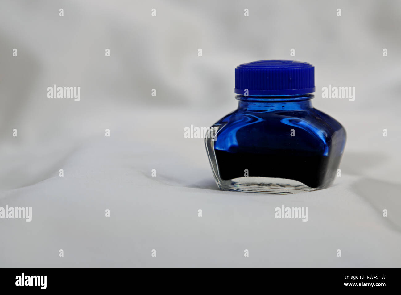 A small half full ink bottle on a white background Stock Photo - Alamy