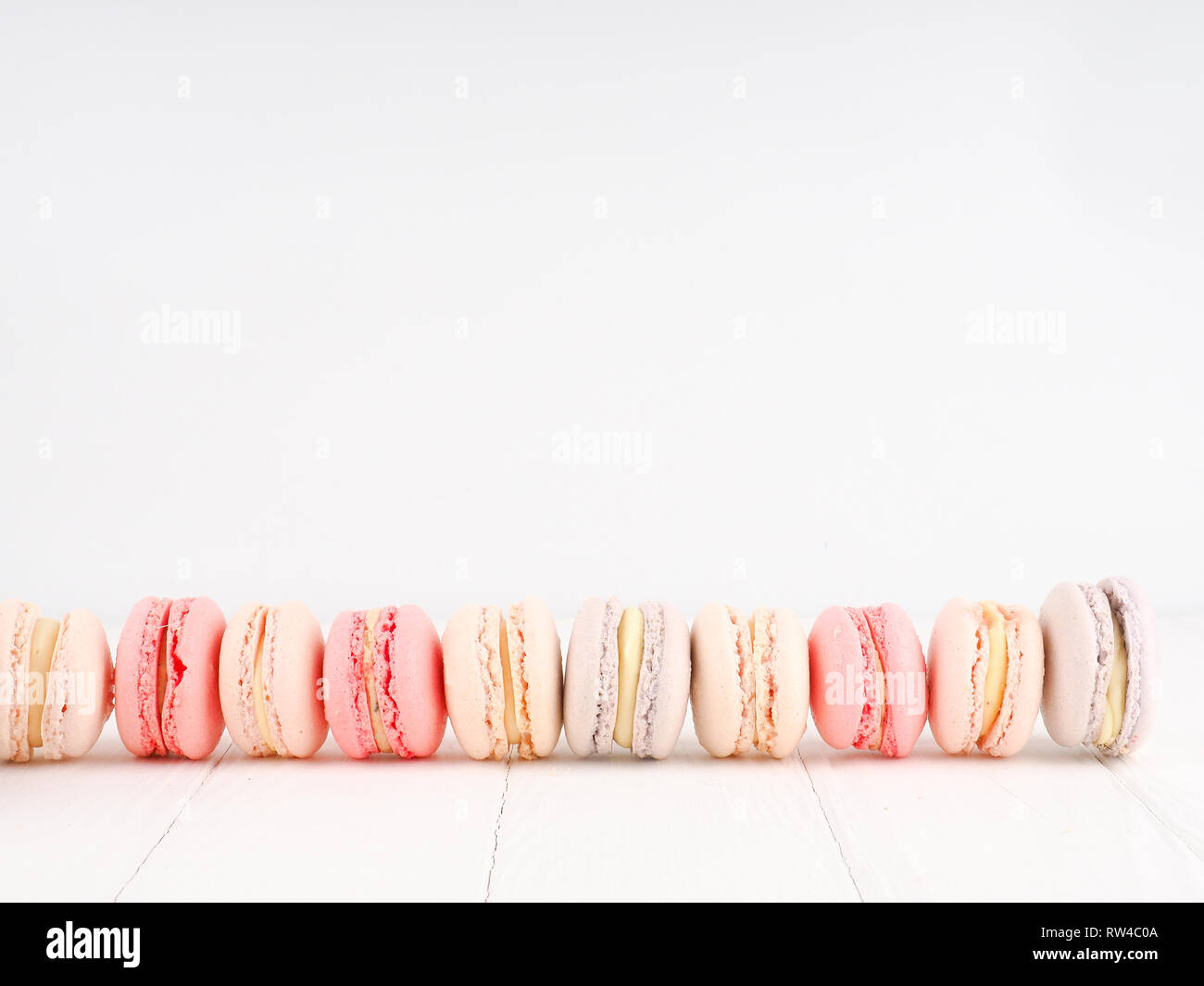Colorful French or Italian macarons stack on white wood table with copy ...