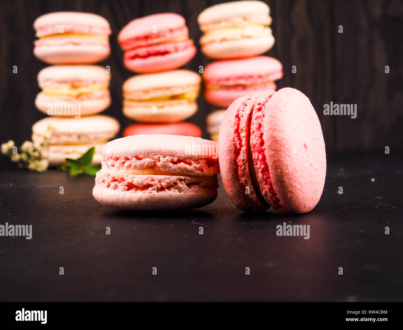 Colorful French or Italian macarons stack on black wood table with copy ...