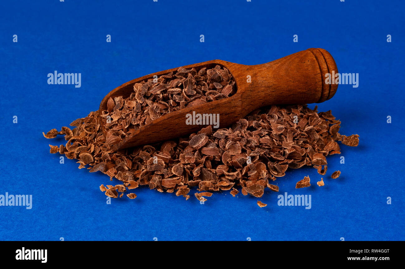 Grated chocolate. Pile of ground chocolate in wooden scoop isolated on ...
