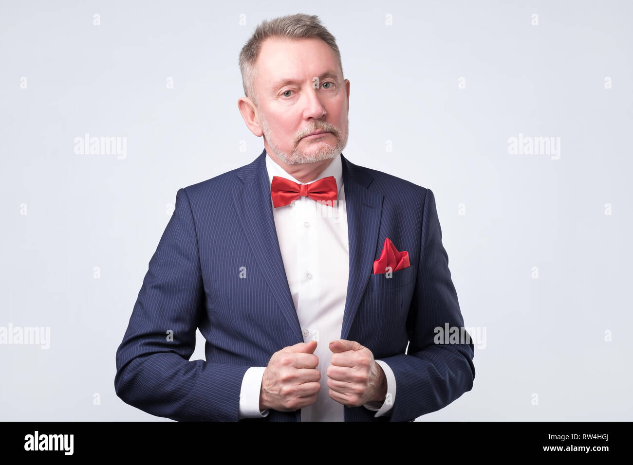 Senior lawyer wearing blue suit with red tie while standing against ...