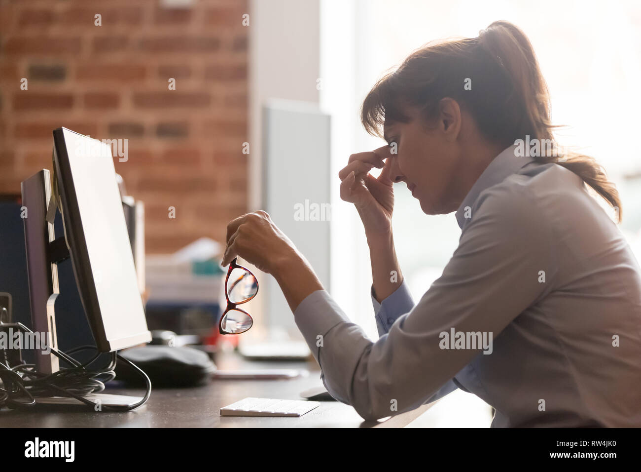 Mature woman taking glasses off hi-res stock photography and images - Alamy