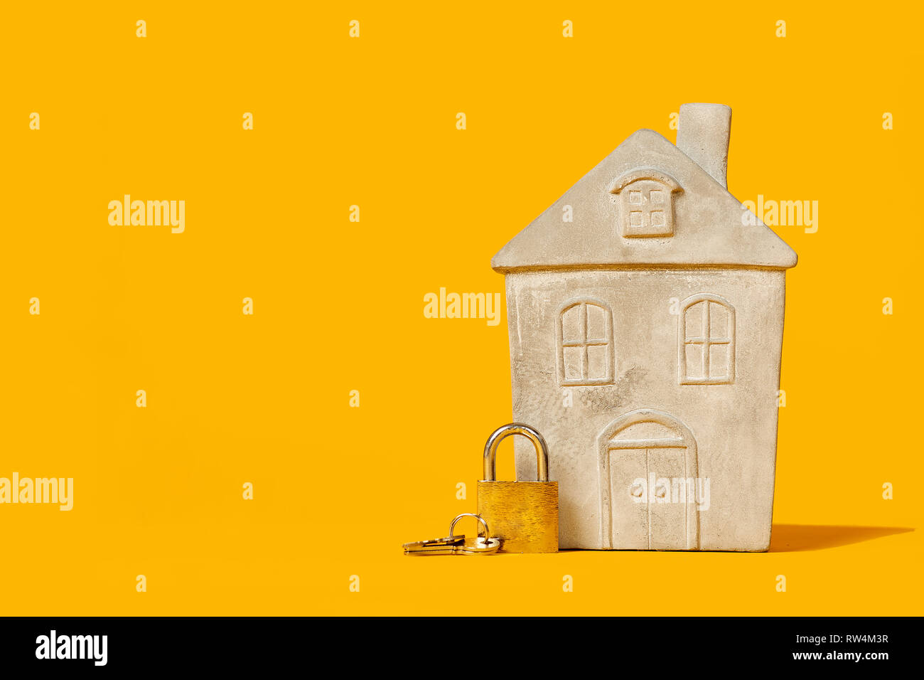 Small model of house with lock Stock Photo - Alamy
