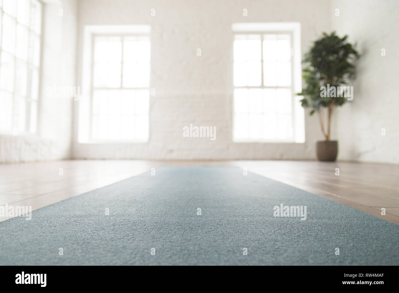 Close up unrolled yoga mat on floor in empty room Stock Photo - Alamy