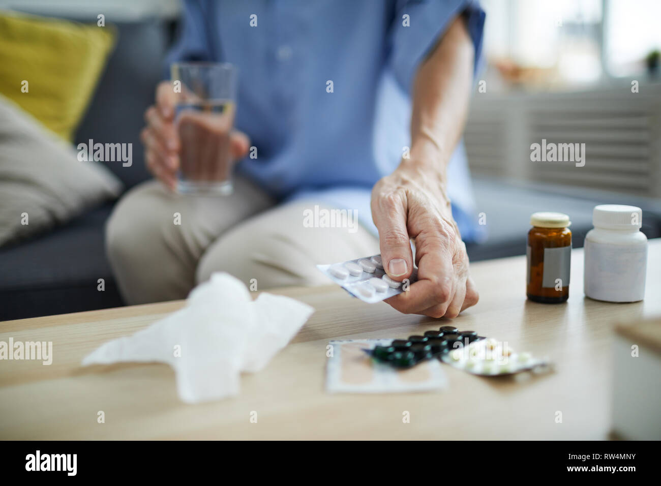 Closeup of unrecognizable senior woman taking pills and medication off ...