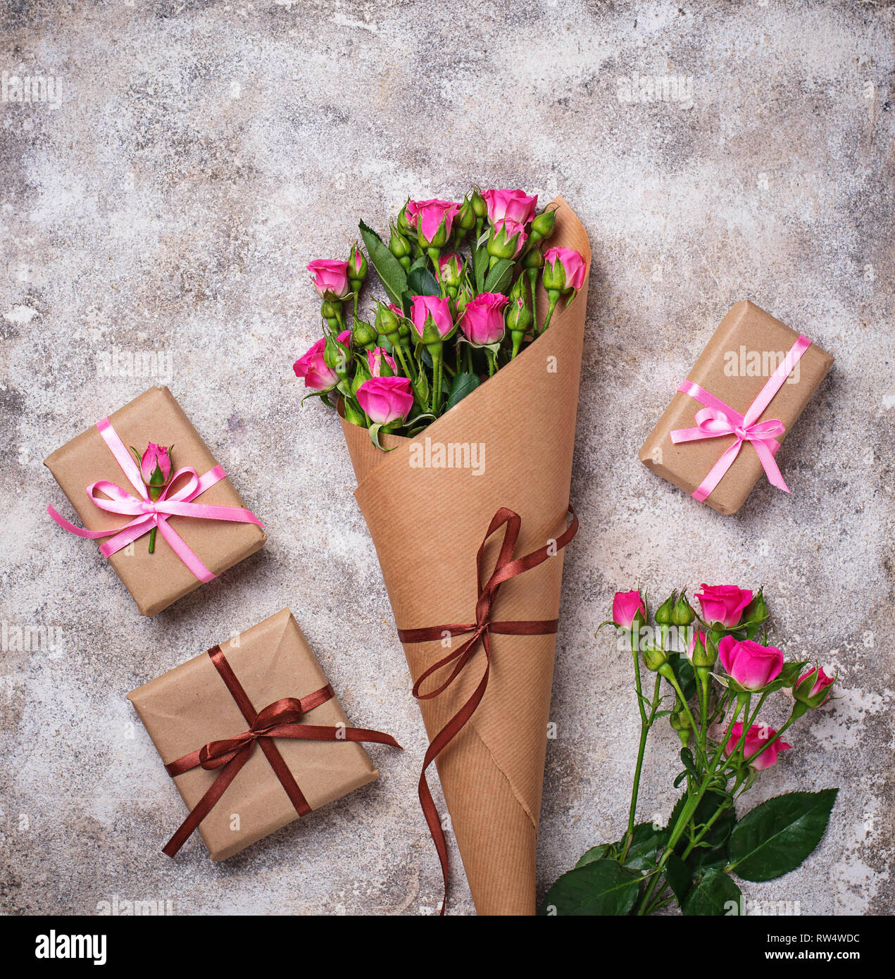 Pink roses bouquet in craft paper and gift boxes. Top view Stock Photo ...
