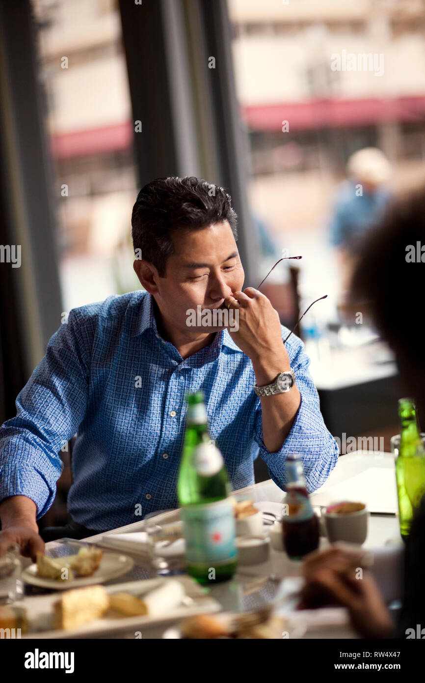 Overworked businessman can't relax enough to enjoy lunch at a ...