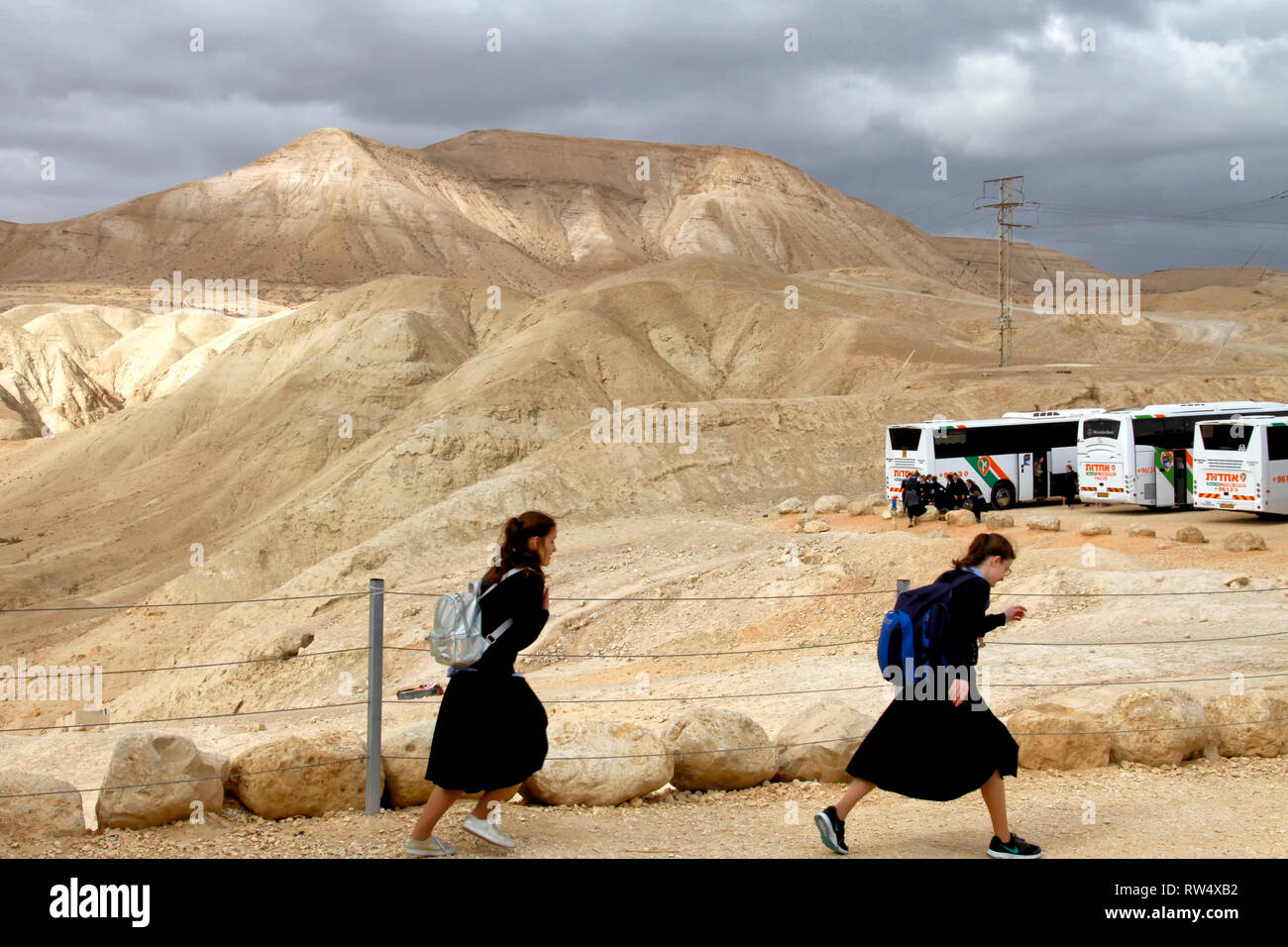 Two Jewish school girls run along a path in the Judean Desert Stock ...