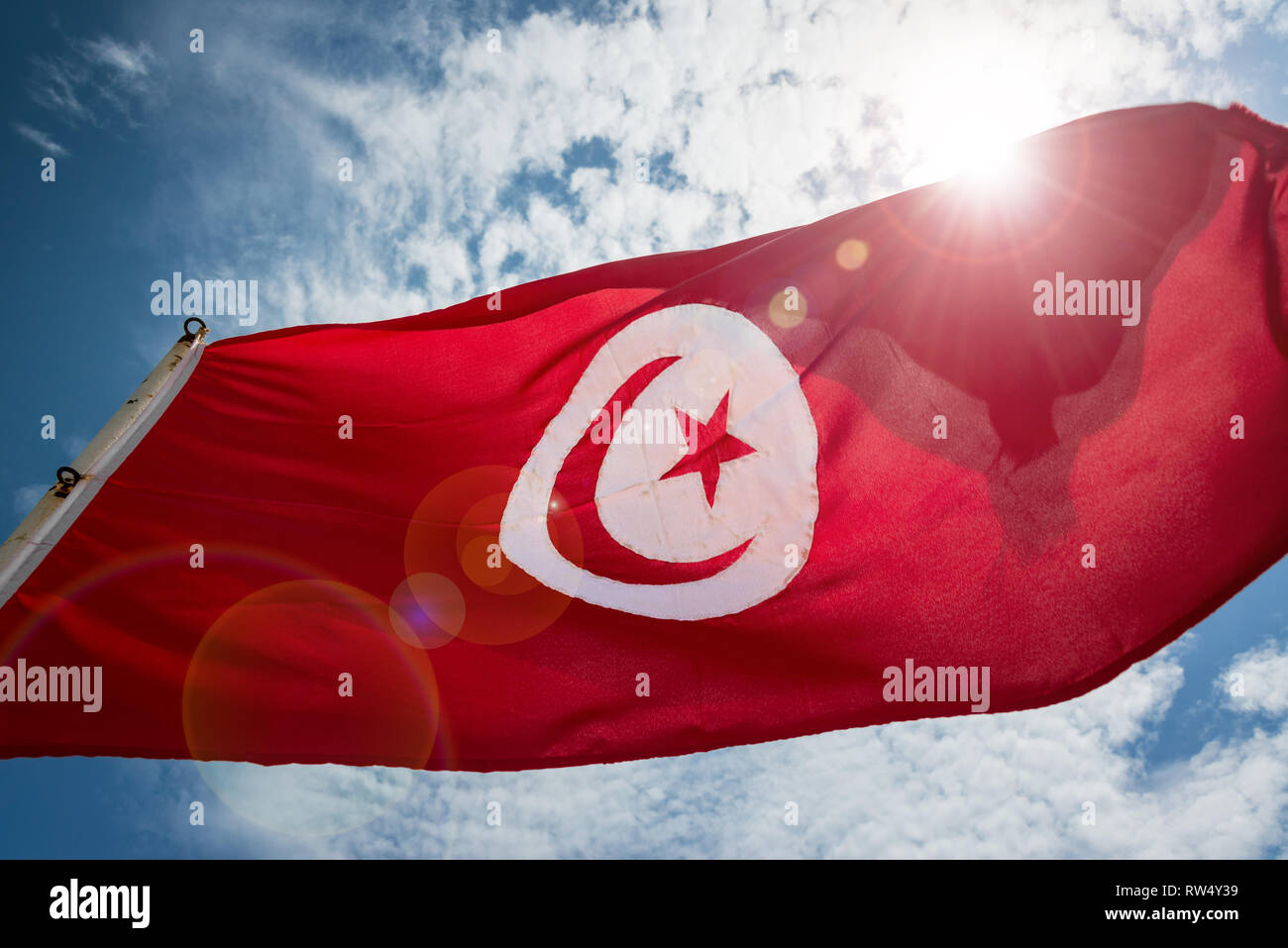 Tunisian flag waving in the wind with lens flare in Monastir, Tunisia ...
