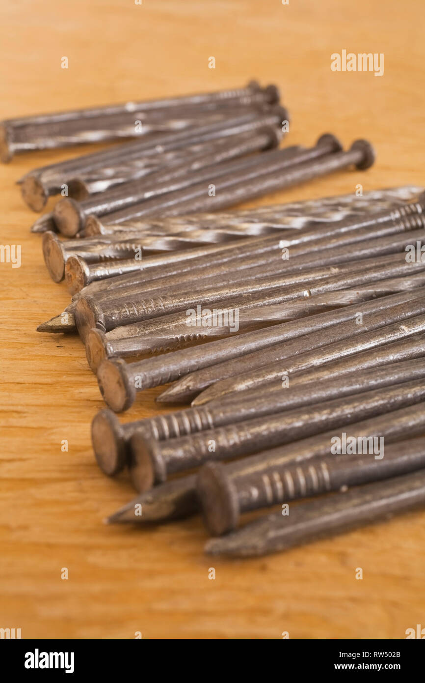 Close-up of steel nails on a plywood floor inside residential home ...