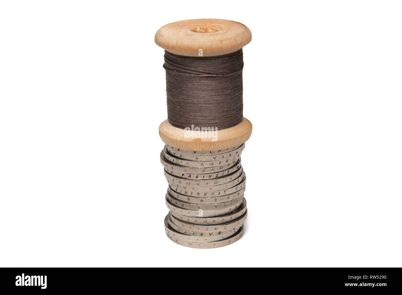 Rows of coins isolated on white background next to multicolored thread ...