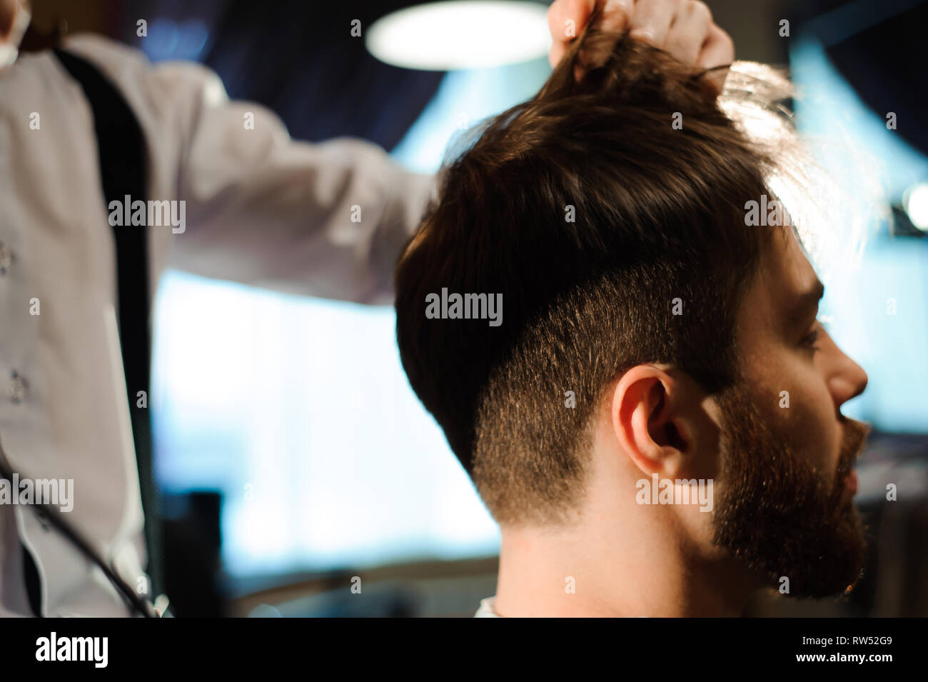 Master cuts hair and beard of men in the barbershop Stock Photo - Alamy
