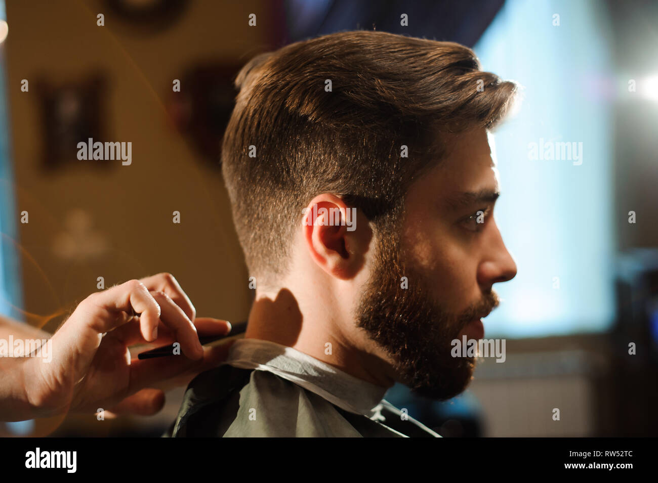 Master cuts hair and beard of men in the barbershop Stock Photo - Alamy