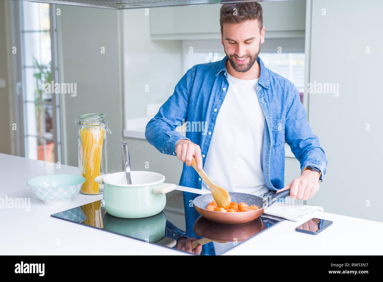 Handsome man cooking pasta at home Stock Photo - Alamy