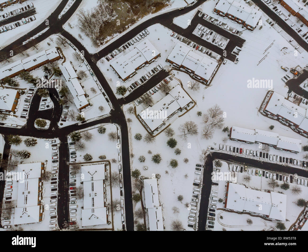 Beautiful snow covered city street with houses with apartment buildings ...