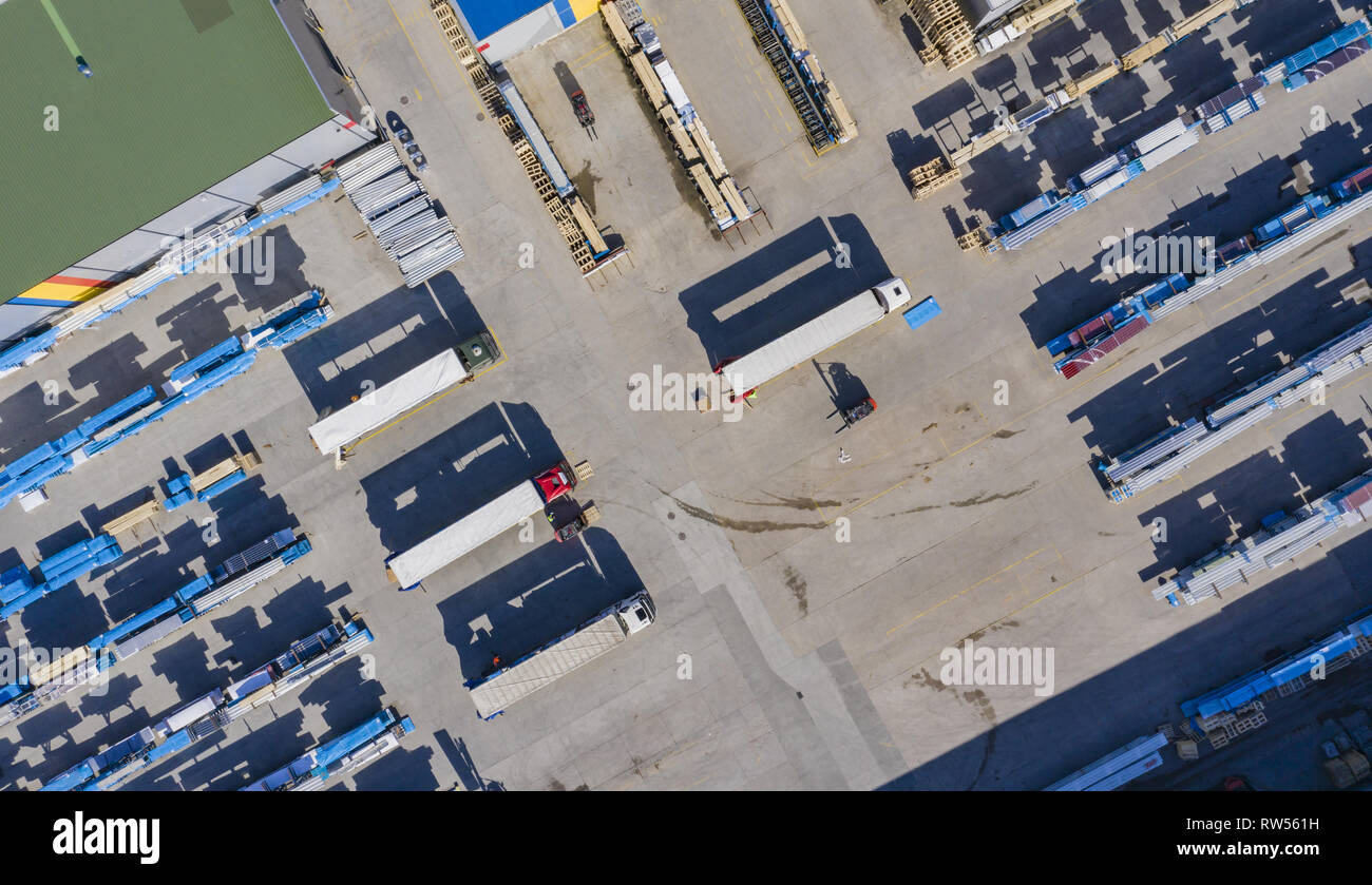 Forklift is putting cargo from warehouse to truck outdoors. Aerial. top ...