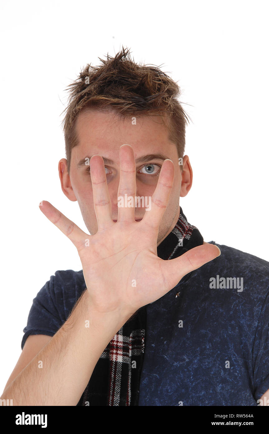 A young man standing from front holding one hand up and looking trough ...