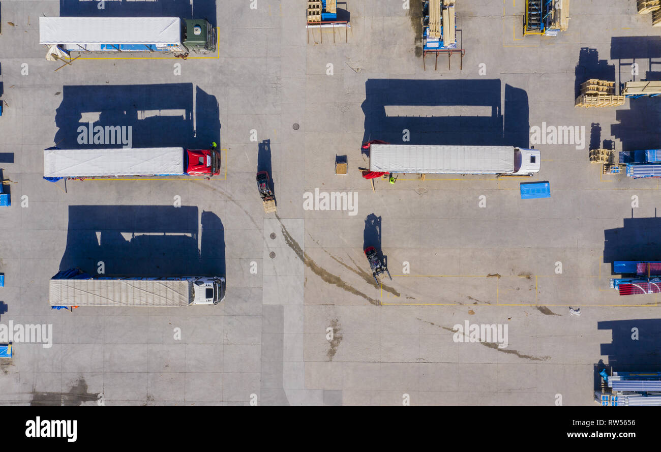 Forklift is putting cargo from warehouse to truck outdoors. Aerial. top ...