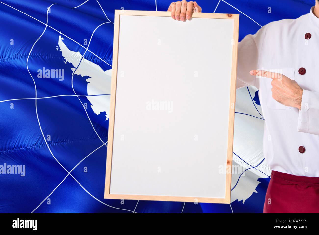 Chef holding blank whiteboard menu on Antarctica flag background. Cook ...