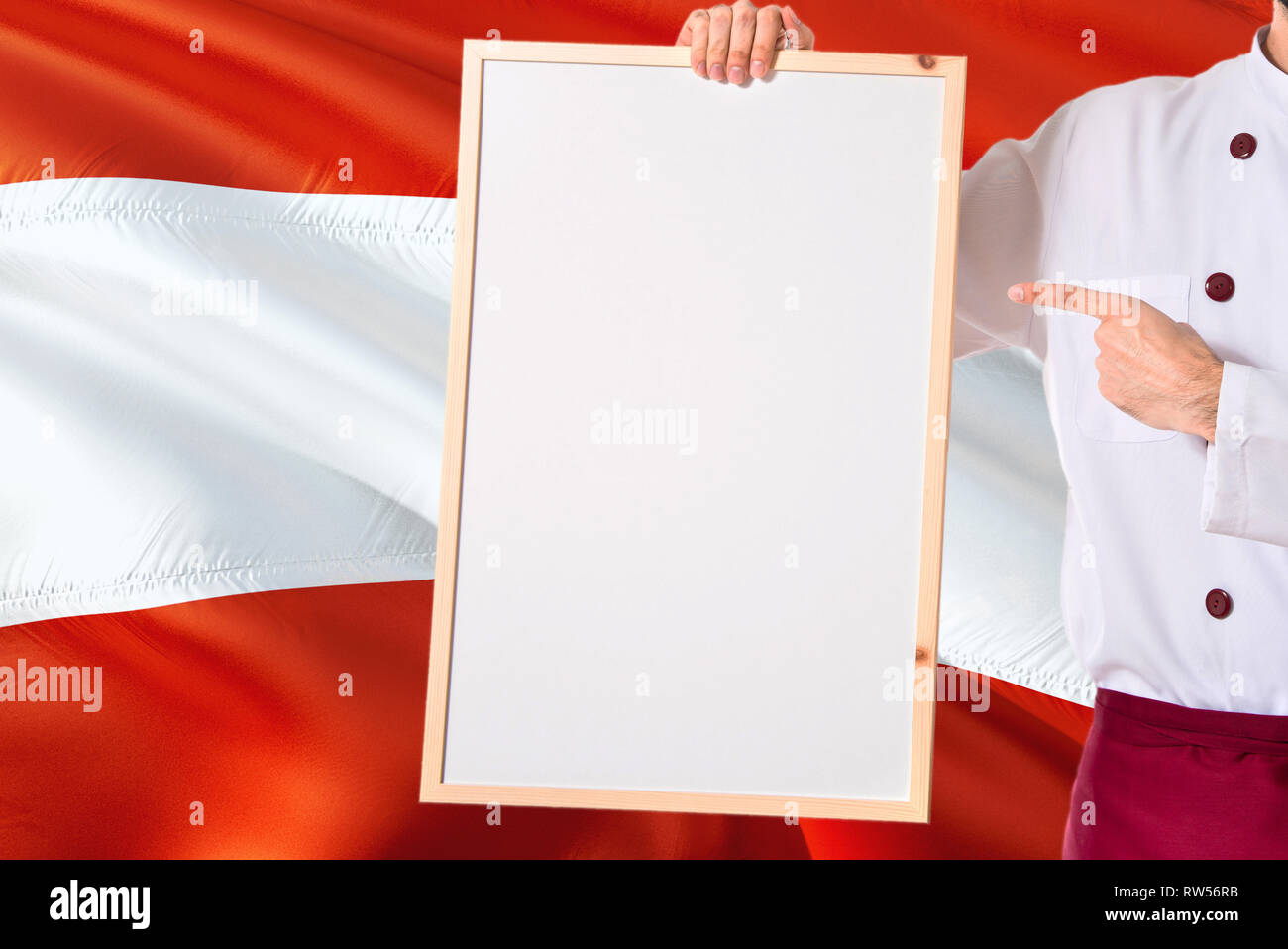 Austrian Chef holding blank whiteboard menu on Austria flag background ...