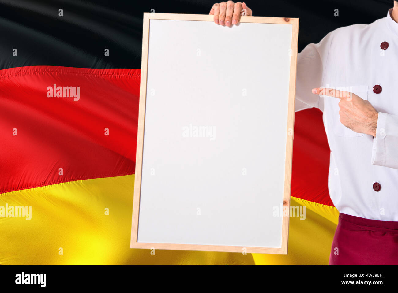 German Chef holding blank whiteboard menu on Germany flag background ...
