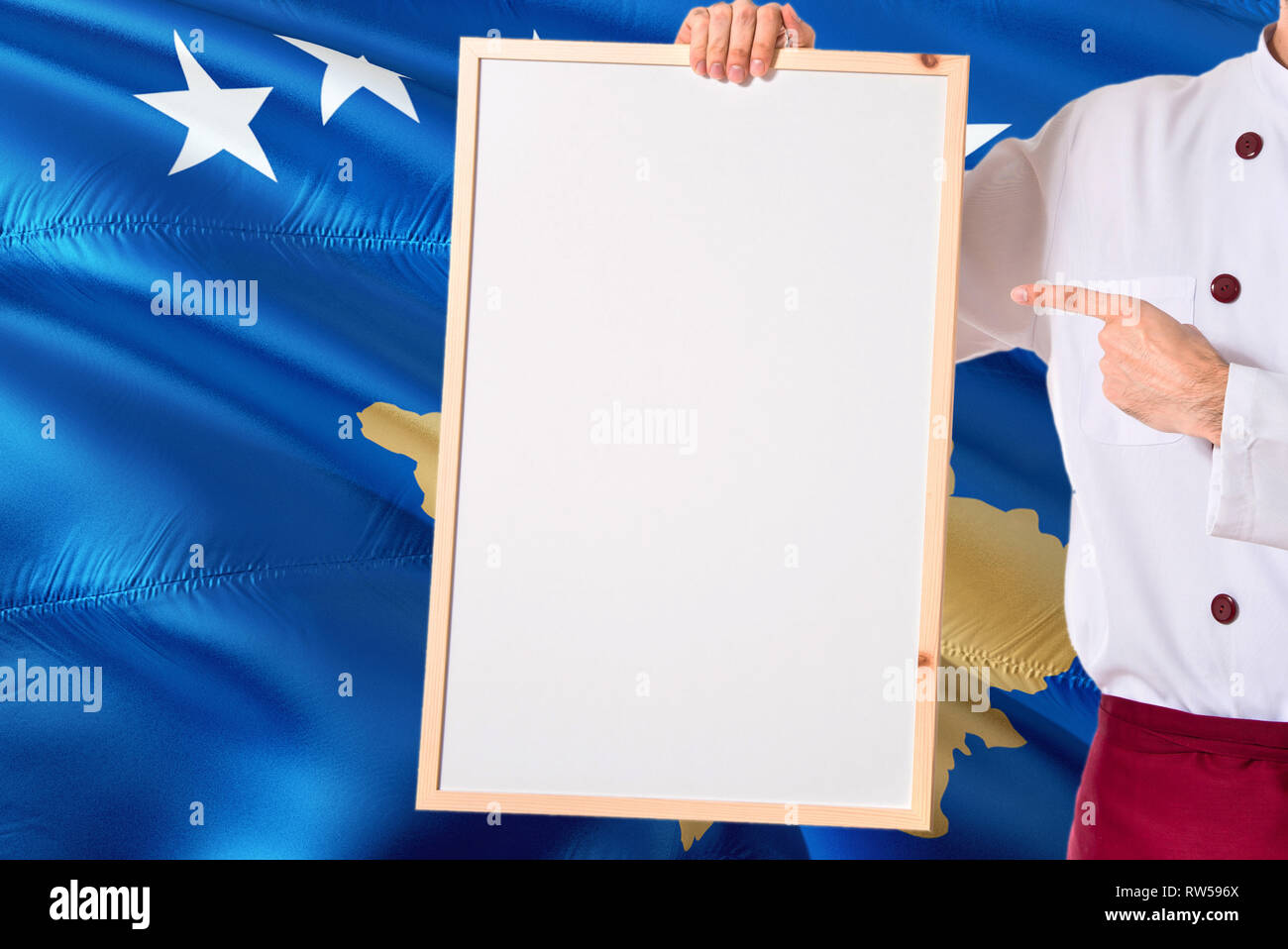 Chef holding blank whiteboard menu on Kosovo flag background. Cook ...
