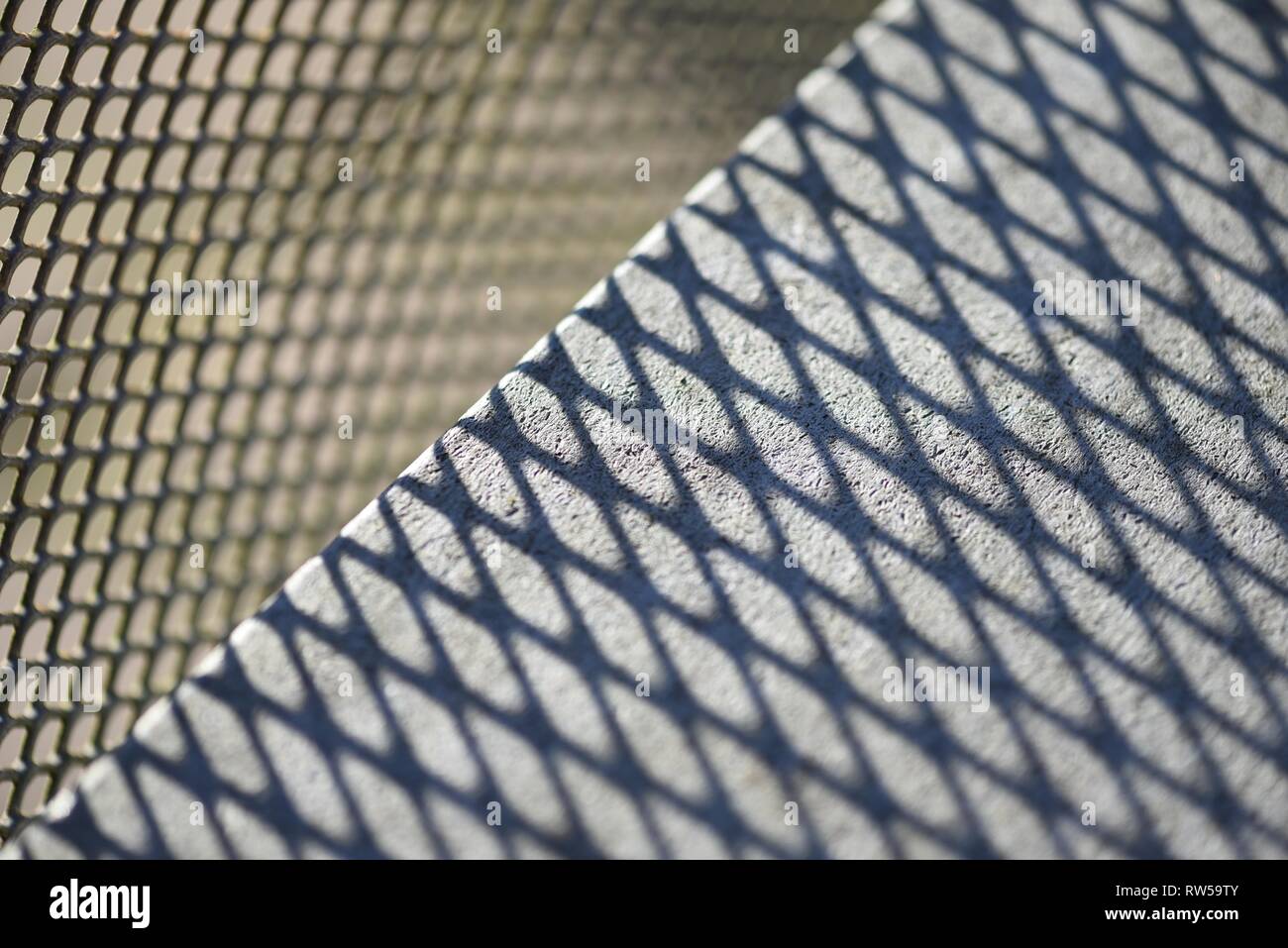 Shadow: the shadow cast from the expanded mesh of a garden chair across ...