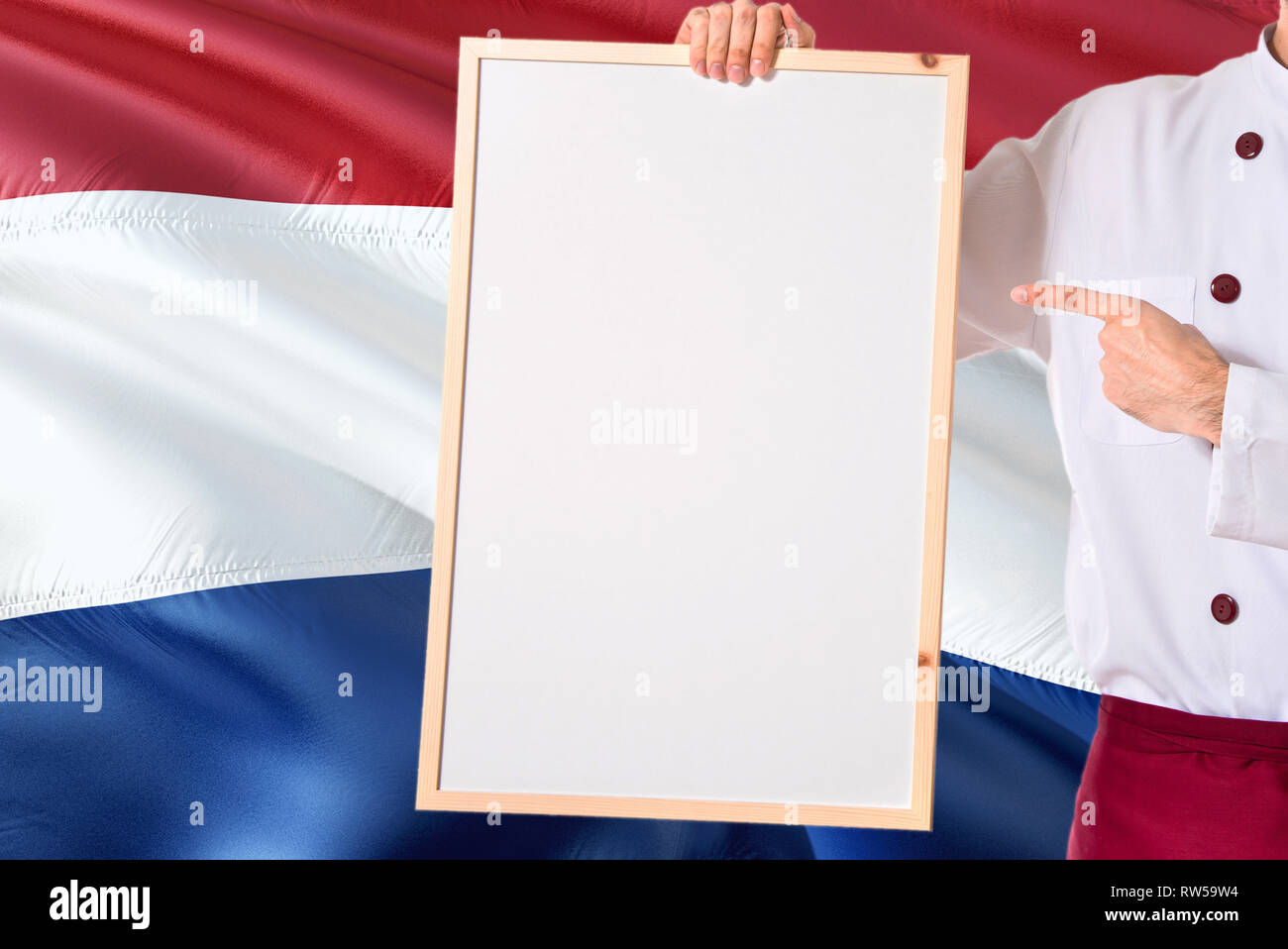 Dutch Chef holding blank whiteboard menu on Netherlands flag background ...