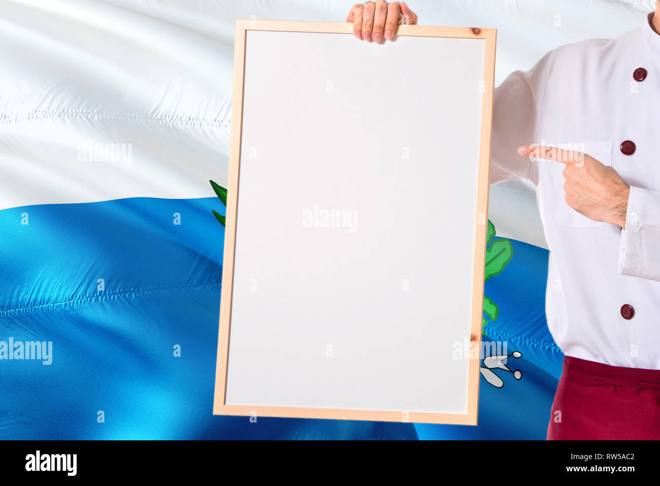 Chef holding blank whiteboard menu on San Marino flag background. Cook ...