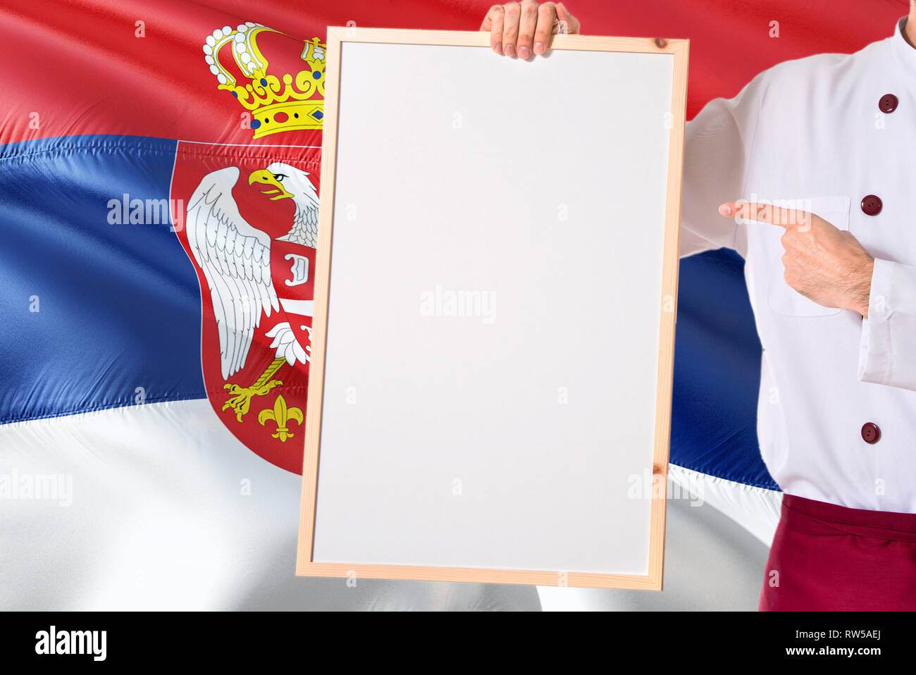 Serbian Chef holding blank whiteboard menu on Serbia flag background ...