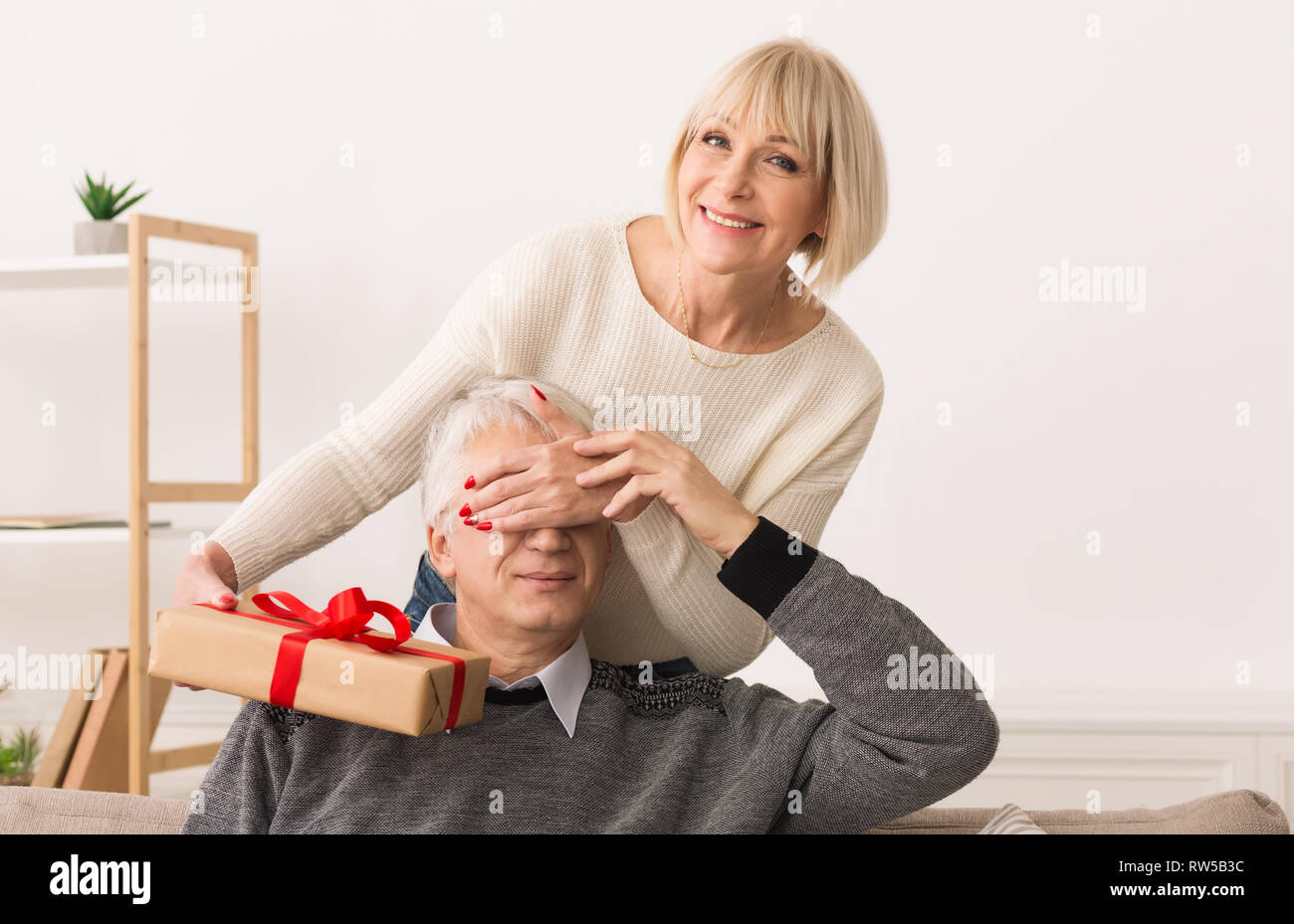 Unexpected surprise. Happy woman making surprise for husband Stock ...