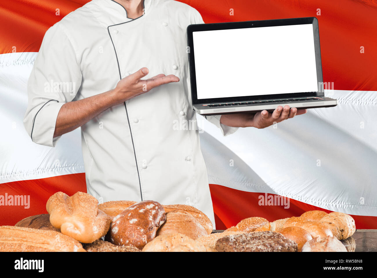 Austrian Baker holding laptop on Austria flag and breads background ...