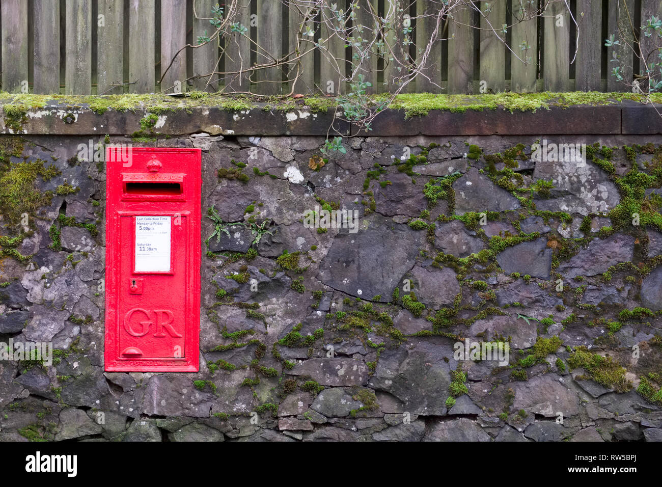 Red post mail box in stone wall Stock Photo - Alamy