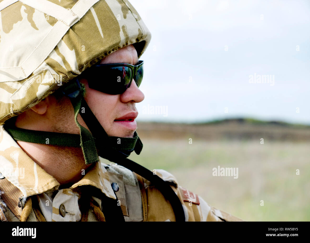 British soldier with the reflection of UK flag in glasses looking ...