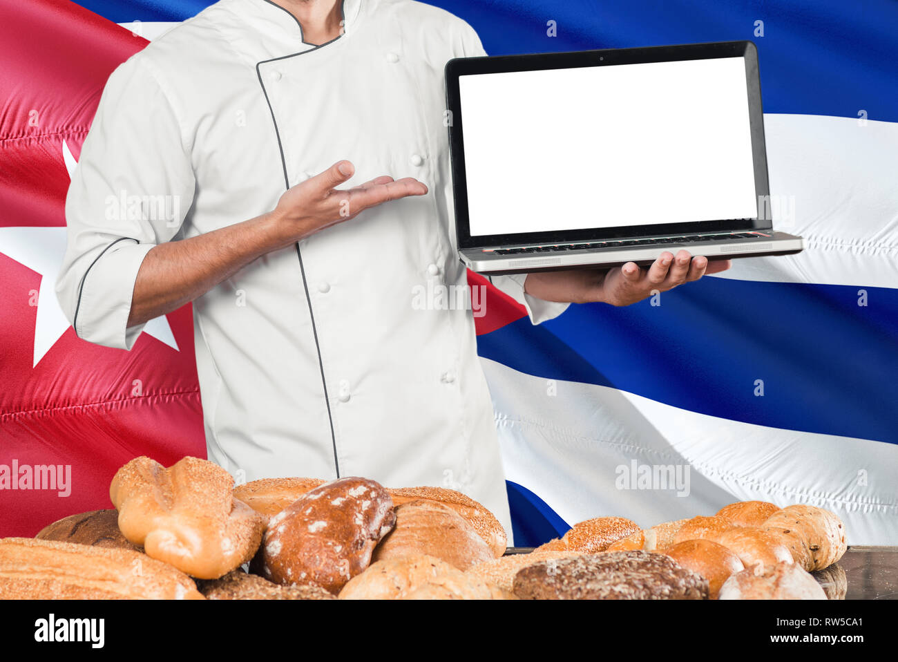 Cuban Baker holding laptop on Cuba flag and breads background. Chef ...