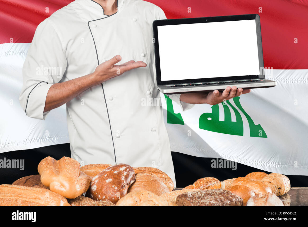 Iraqi Baker holding laptop on Iraq flag and breads background. Chef ...