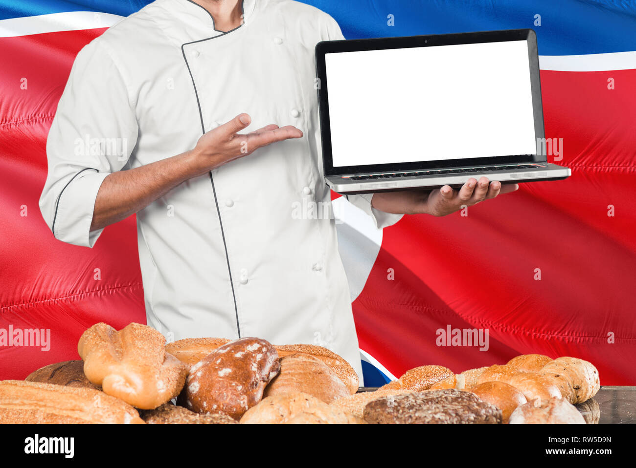 North Korean Baker holding laptop on North Korea flag and breads ...
