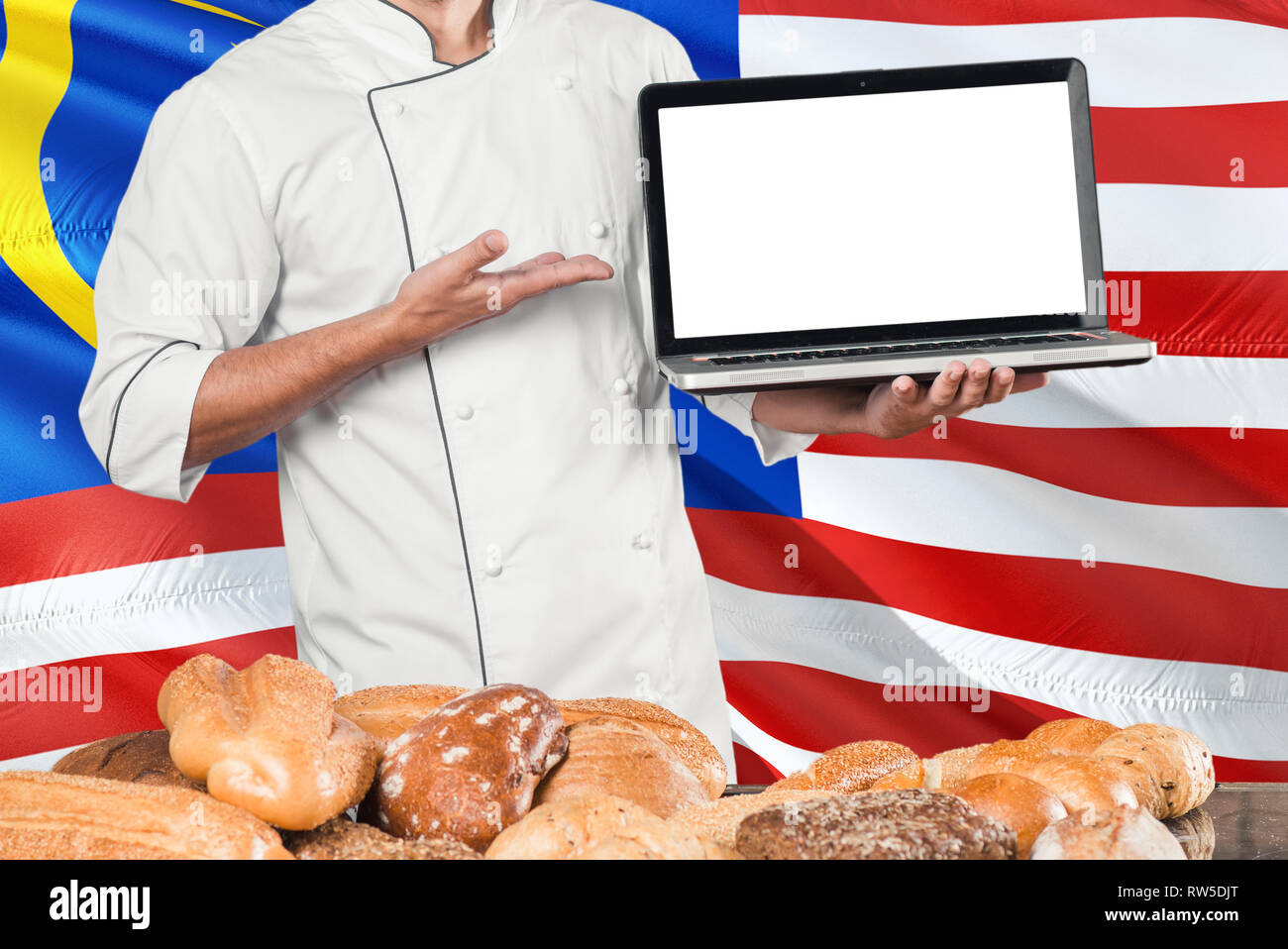 Malaysian Baker holding laptop on Malaysia flag and breads background ...