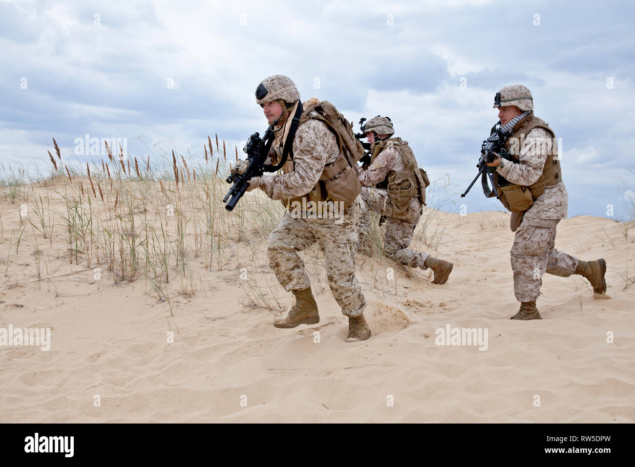 U.S. Marines run through the desert through the military operation ...