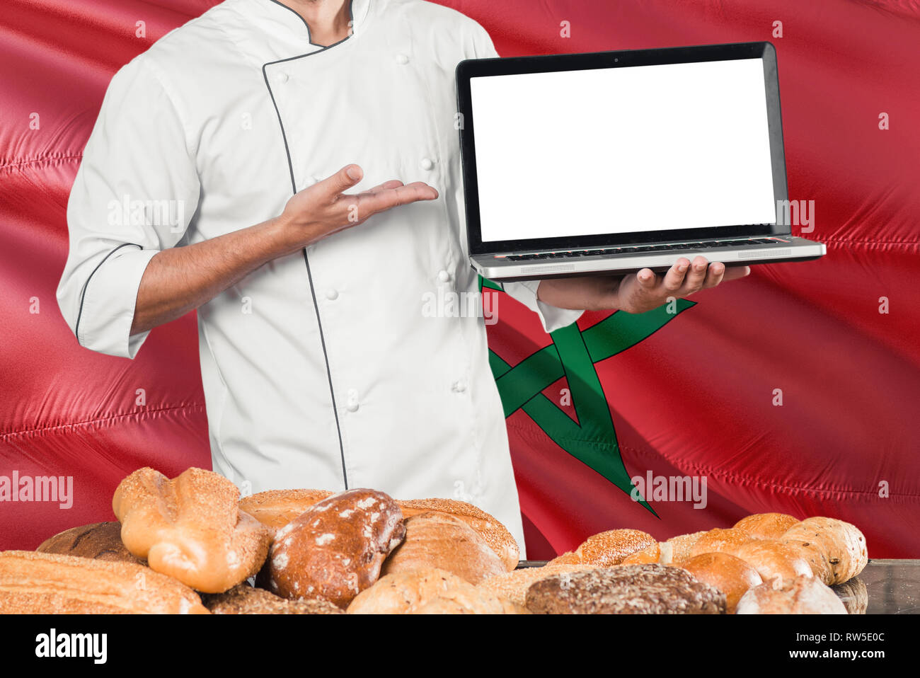 Moroccan Baker holding laptop on Morocco flag and breads background ...
