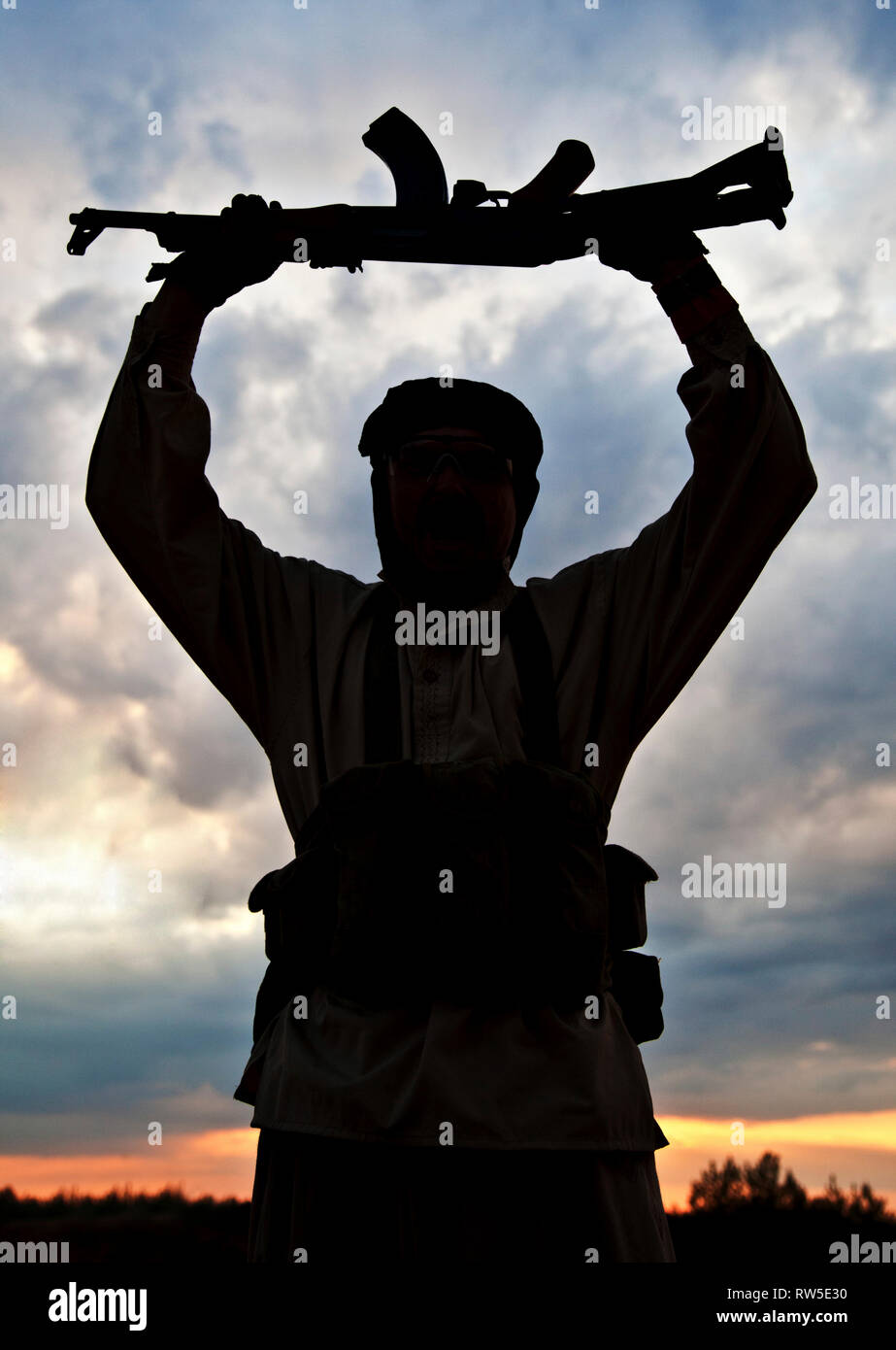 Silhouette of muslim militant with rifle Stock Photo - Alamy