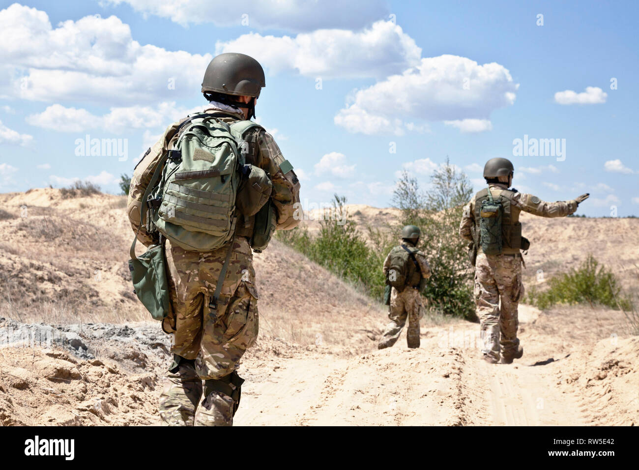 Squad of soldiers patrolling across the desert Stock Photo - Alamy