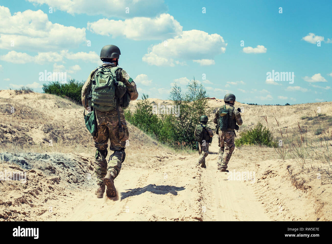 Squad of soldiers patrolling across the desert Stock Photo - Alamy