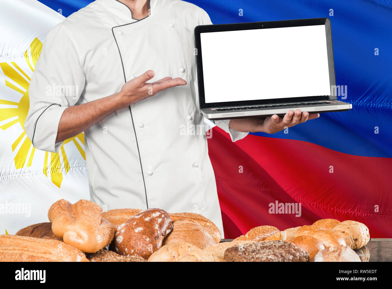 Filipino Baker holding laptop on Philippines flag and breads background ...