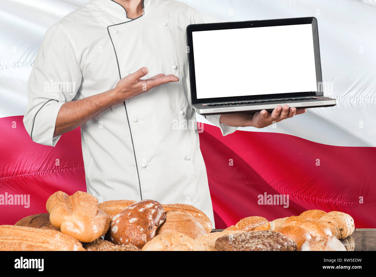 Polish Baker holding laptop on Poland flag and breads background. Chef ...