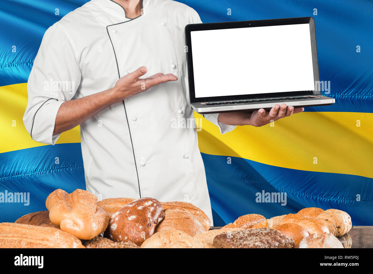 Swedish Baker holding laptop on Sweden flag and breads background. Chef ...