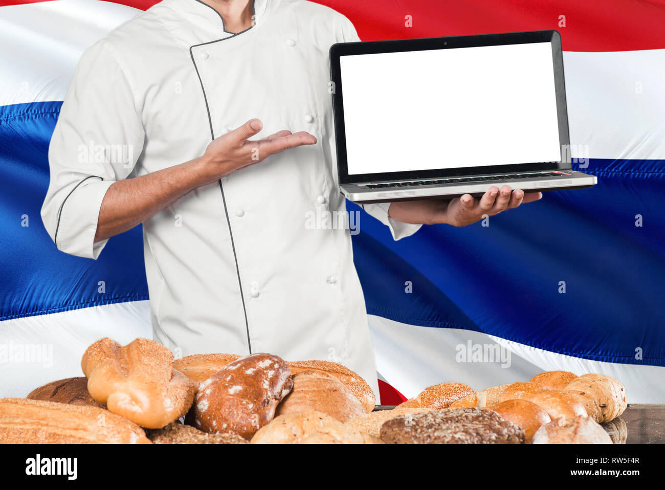 Thai Baker holding laptop on Thailand flag and breads background. Chef ...